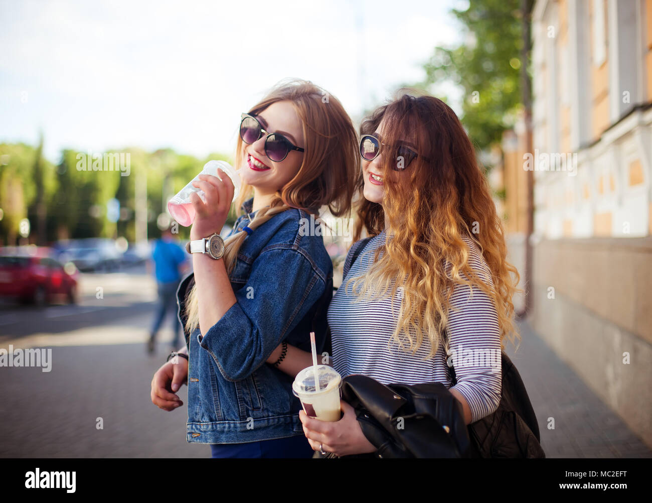 Outdoor lifestyle portrait of two happy best friend girls walk laugh ...