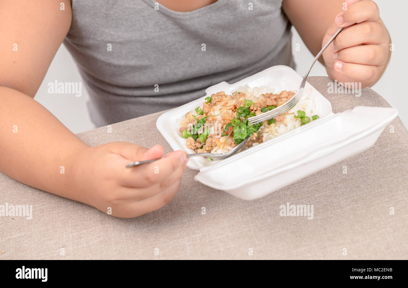 Obese fat boy eating fried rice in foam box on white background, junk ...