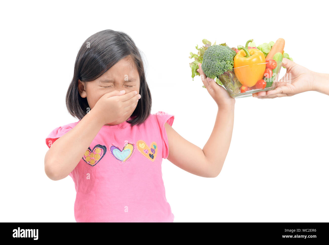 asian child girl with expression of disgust against vegetables isolated ...