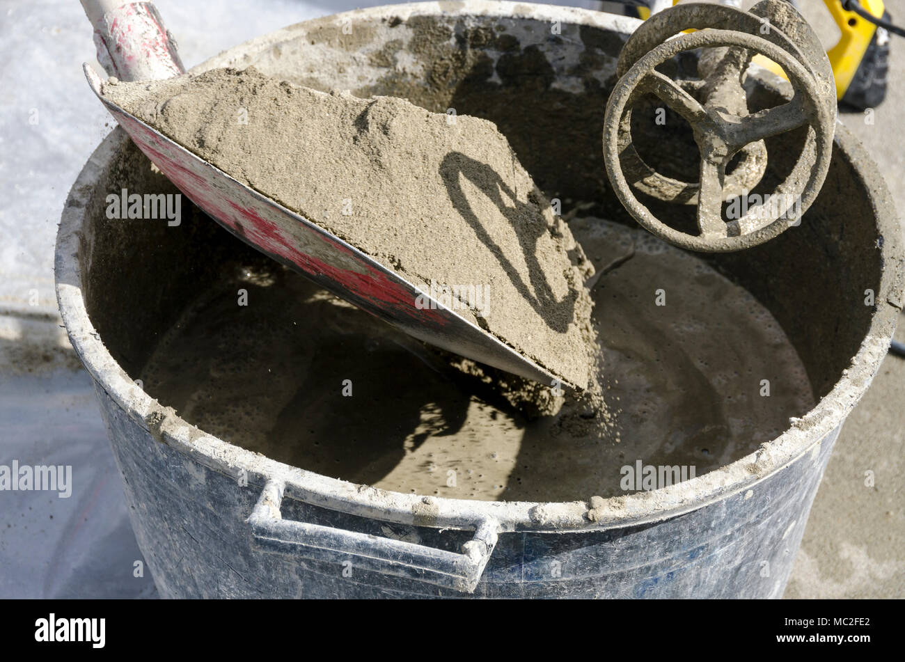 worker who throws cement on a building site for the renovation of a ...