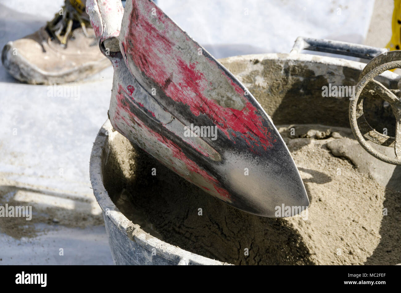 worker who throws cement on a building site for the renovation of a ...