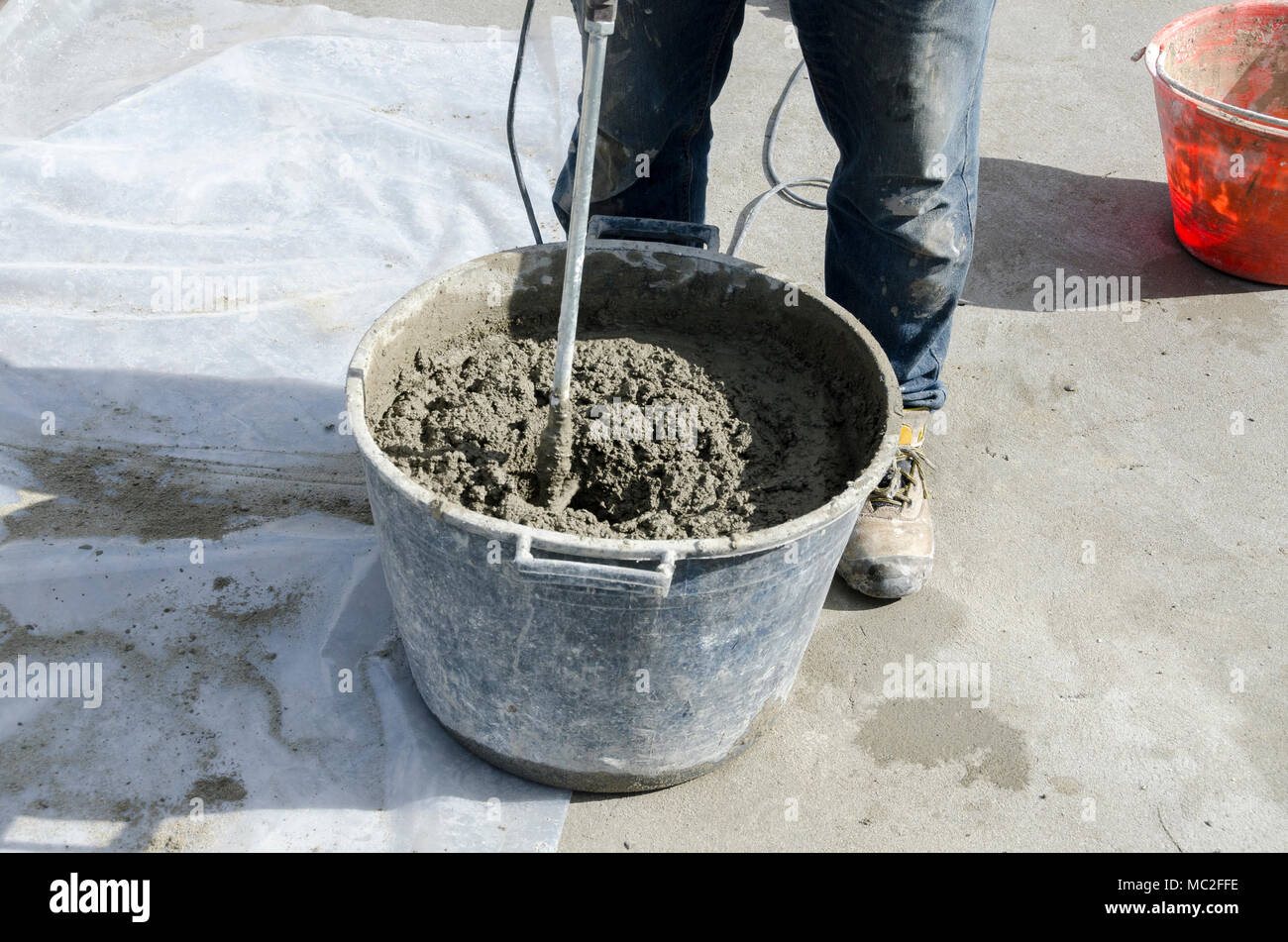worker who throws cement on a building site for the renovation of a ...