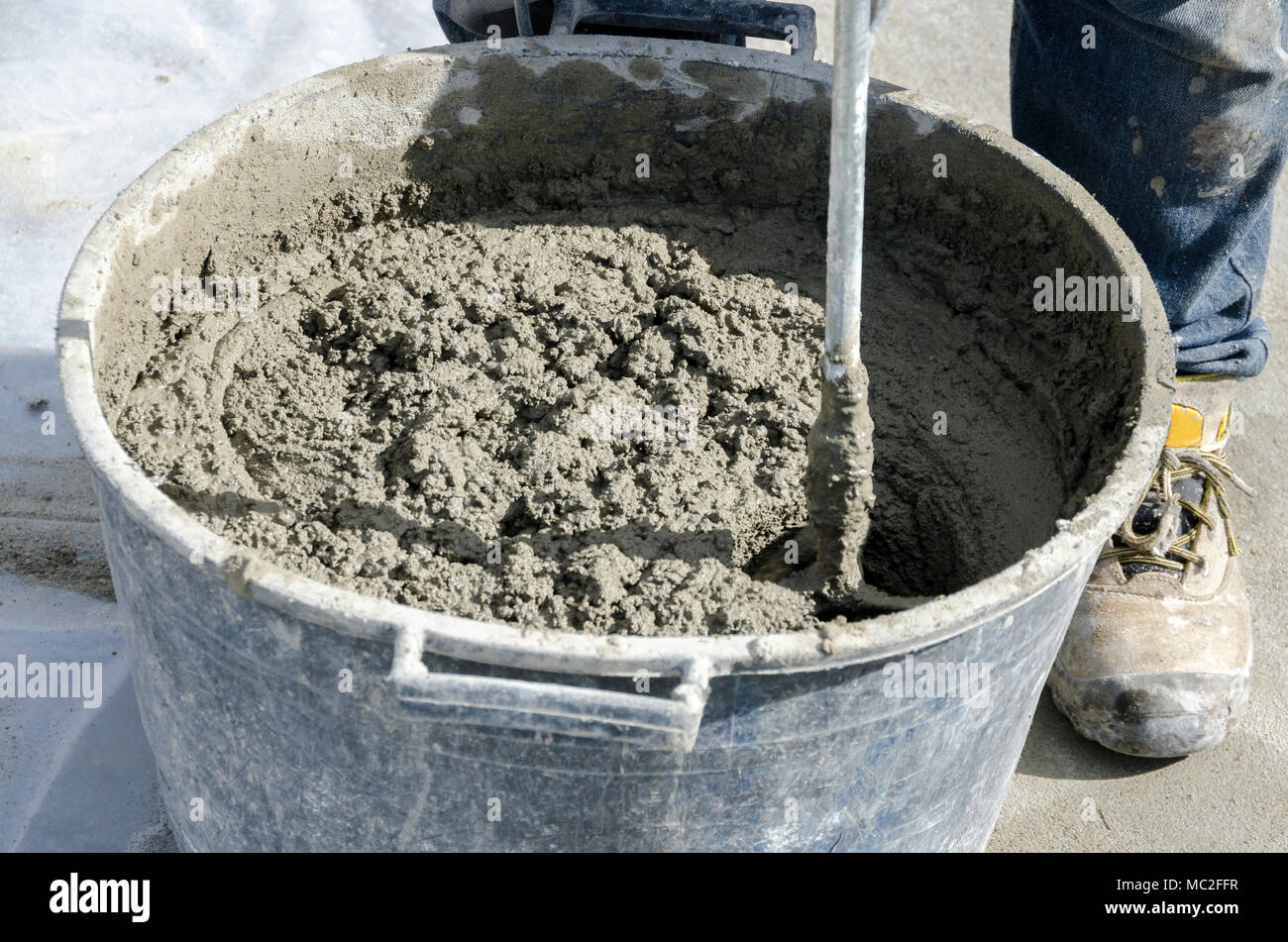 worker who throws cement on a building site for the renovation of a ...