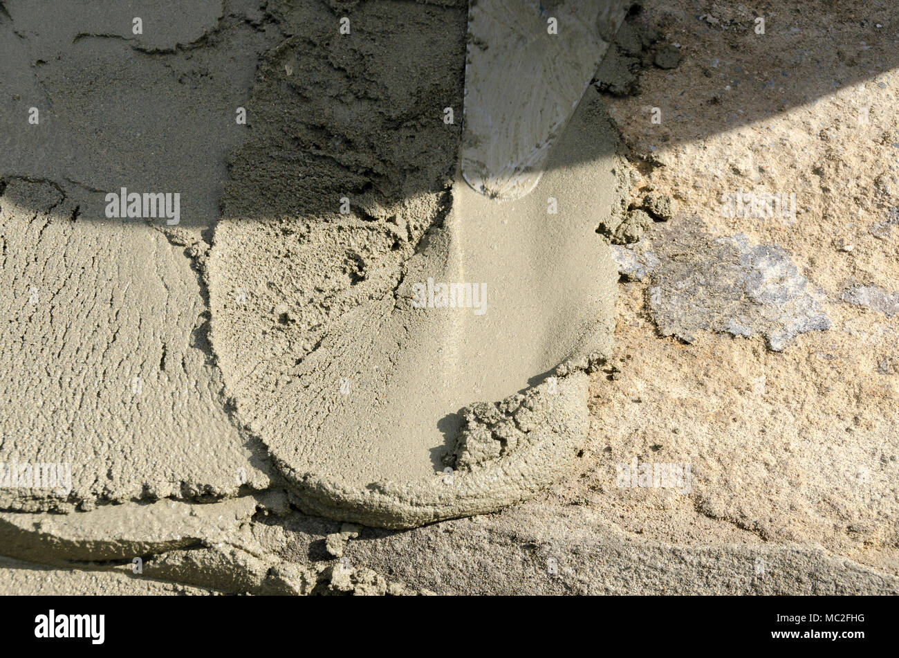 worker who throws cement on a building site for the renovation of a ...