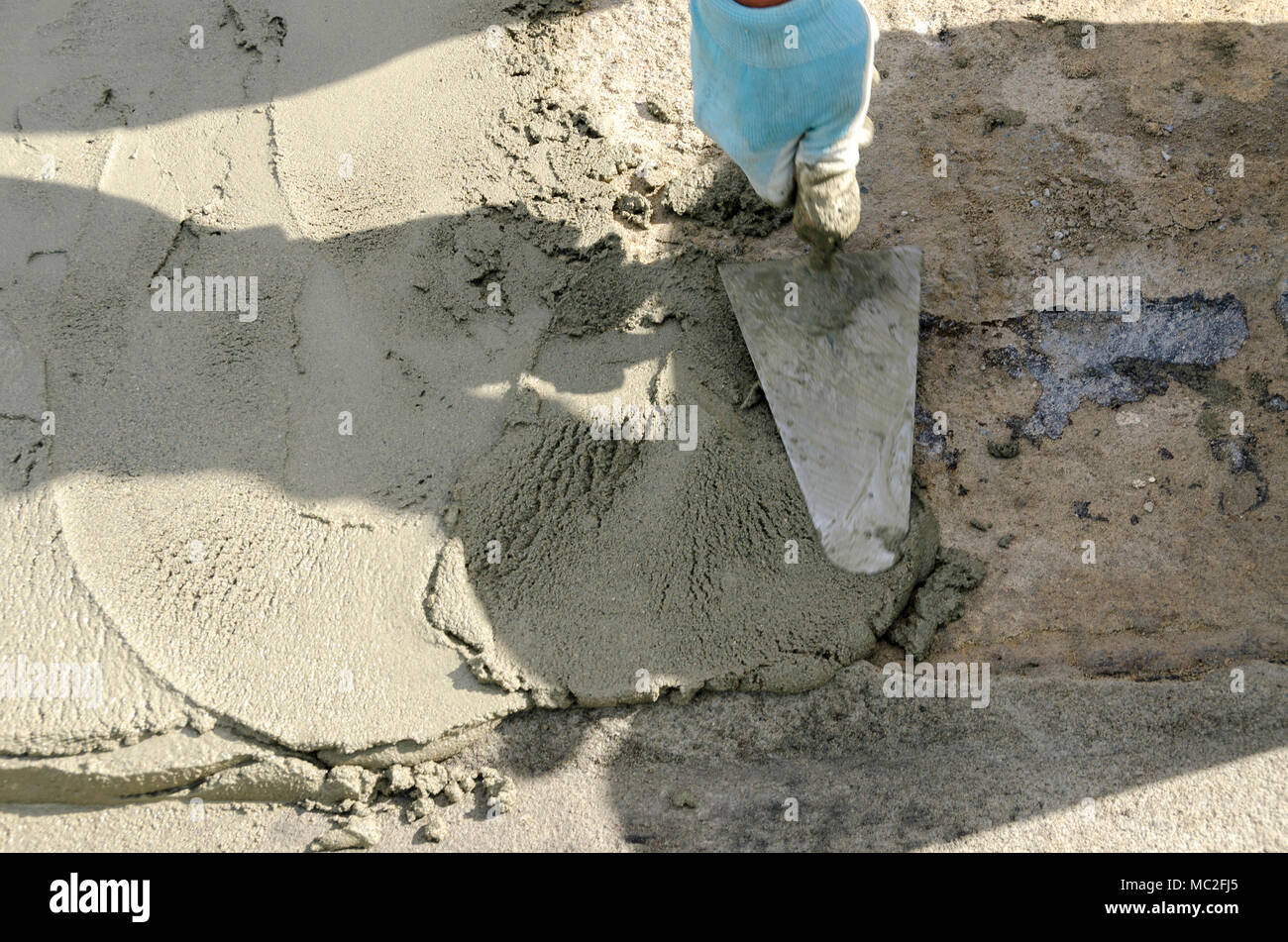 worker who throws cement on a building site for the renovation of a ...