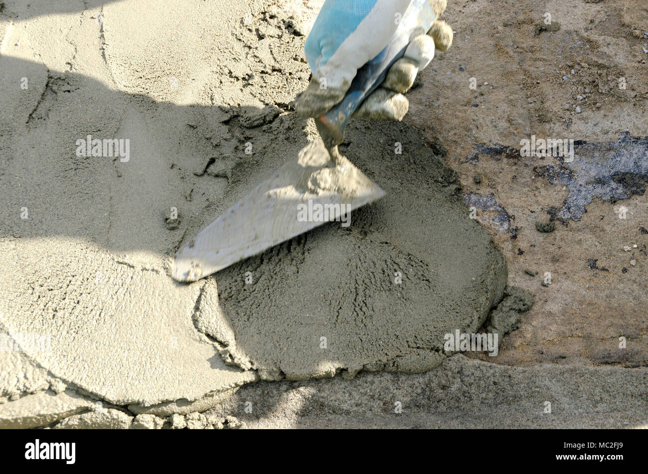 worker who throws cement on a building site for the renovation of a ...