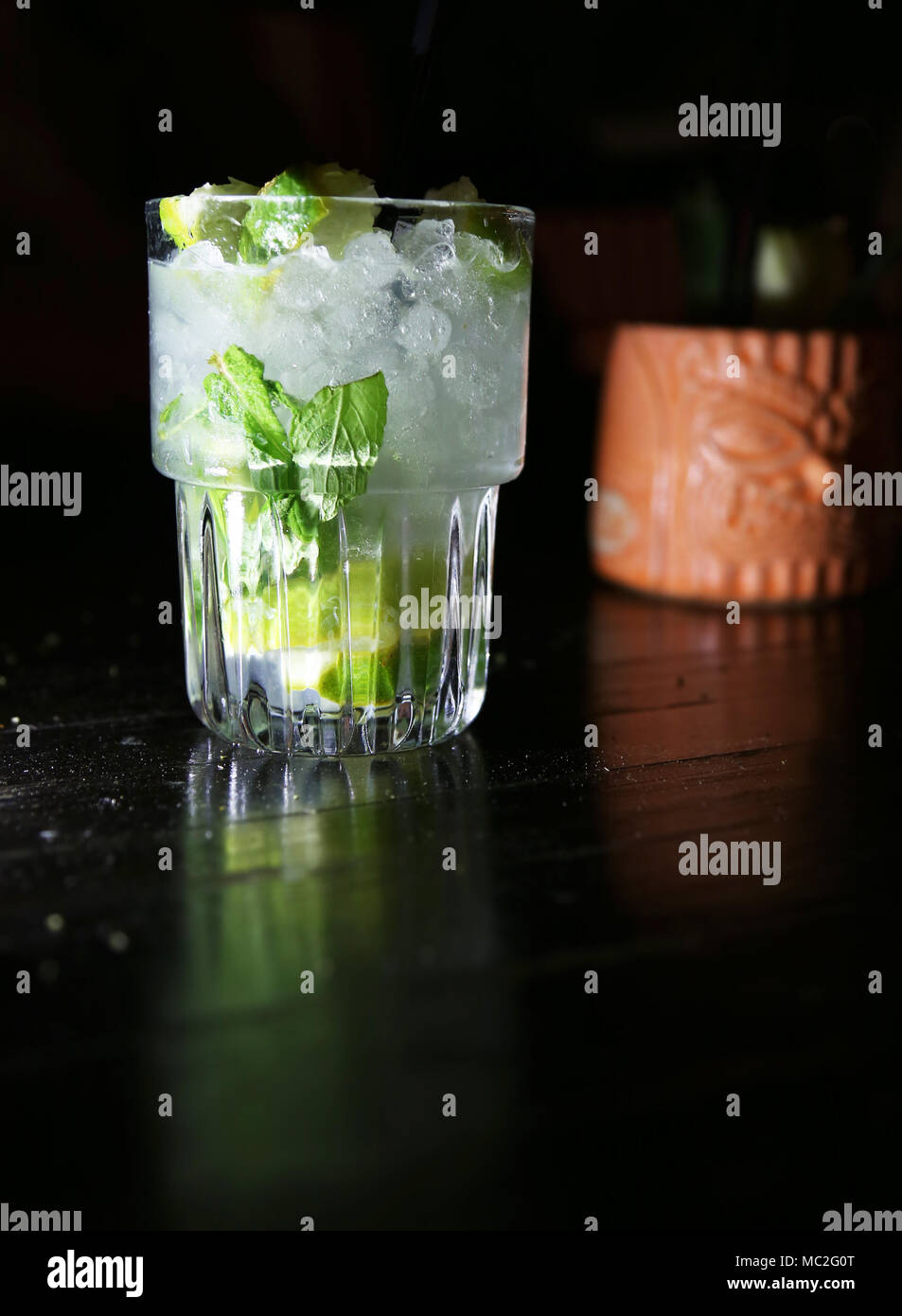 cocktail drinks with lime juice and grated ice on black background ...