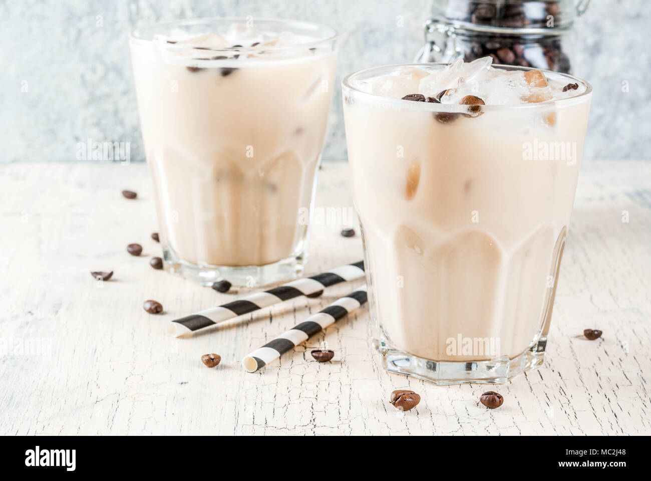 Summer cold Iced coffee frappe with milk and ice cubes, light concrete ...