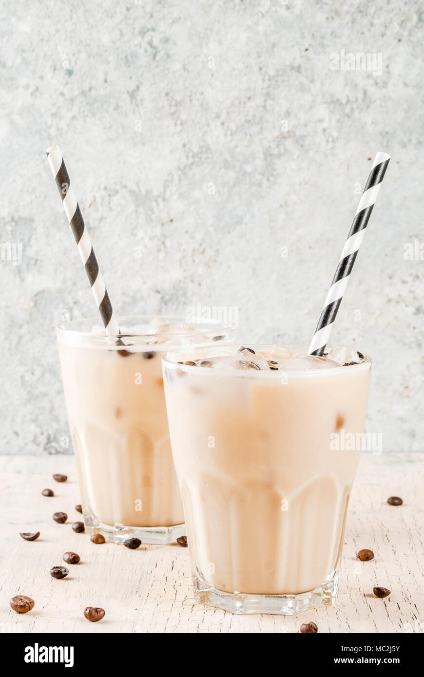 Summer cold Iced coffee frappe with milk and ice cubes, light concrete ...