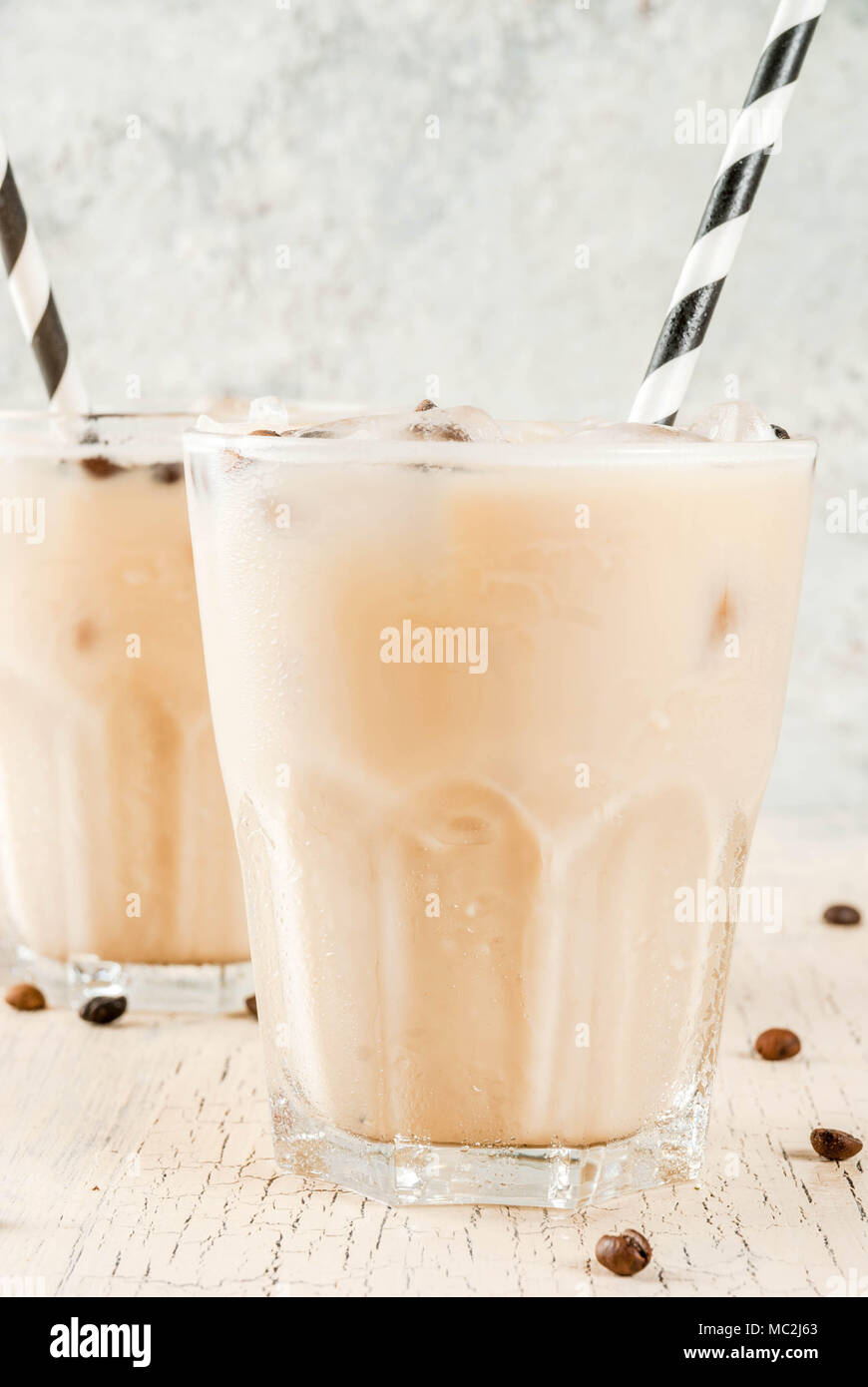 Summer cold Iced coffee frappe with milk and ice cubes, light concrete ...