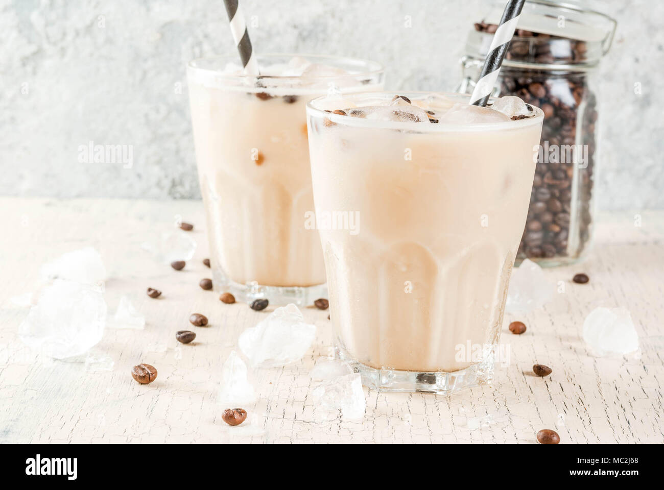 Summer cold Iced coffee frappe with milk and ice cubes, light concrete ...