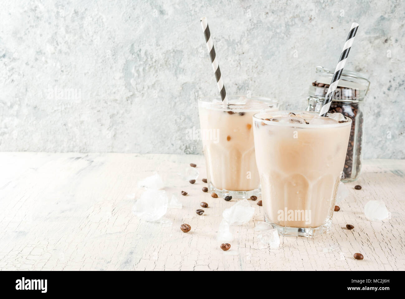 Summer cold Iced coffee frappe with milk and ice cubes, light concrete ...