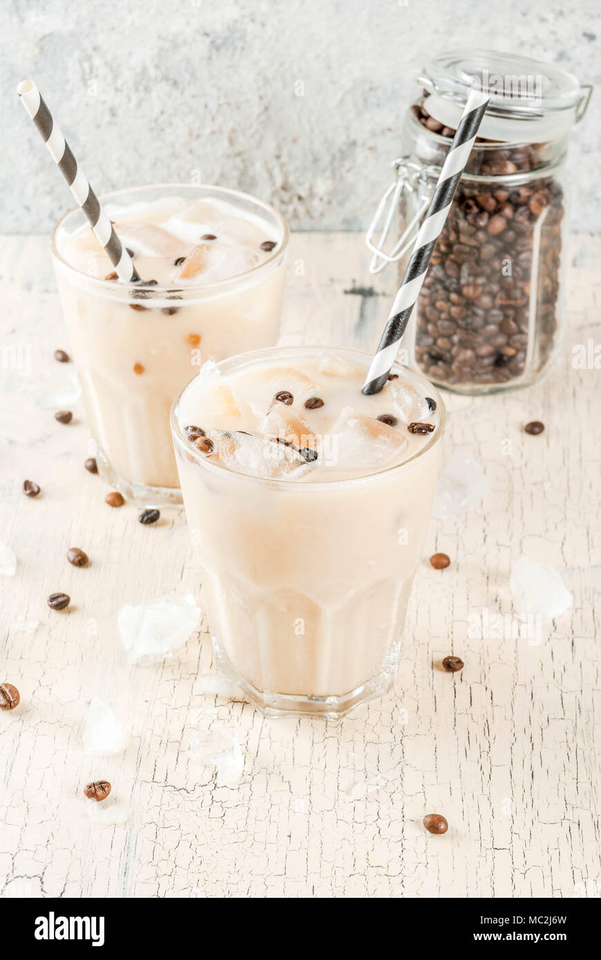 Summer cold Iced coffee frappe with milk and ice cubes, light concrete ...