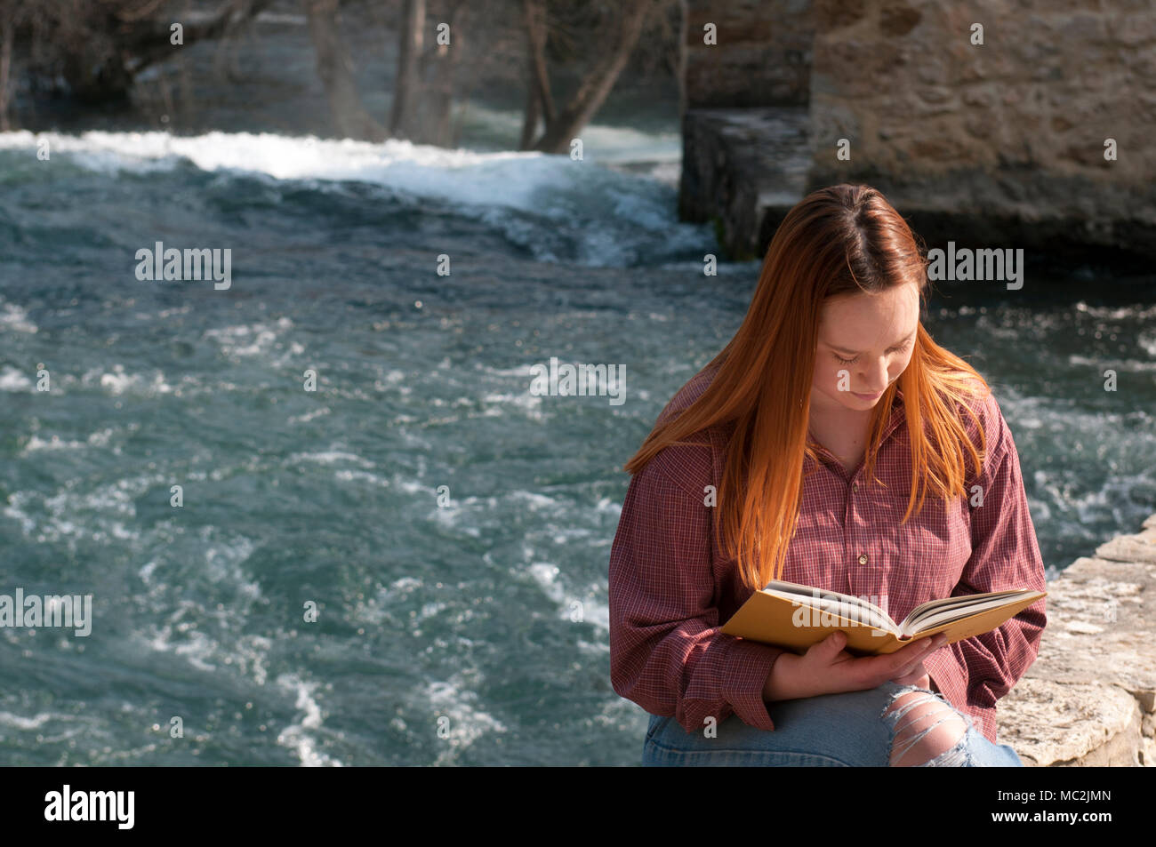 girl reading a book by the river Stock Photo - Alamy