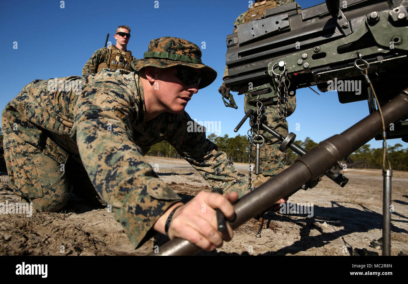 Sgt. Dustin McPhearson, a platoon sergeant, steadies a tripod for the ...