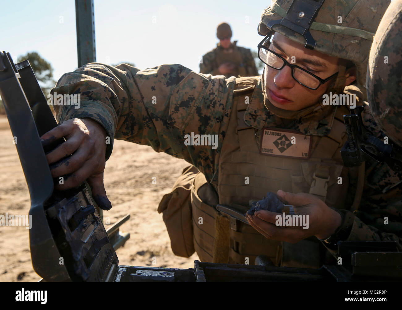 Lance Cpl. Alfredo Olivo applies lubricant to a MK19 machine gun before ...