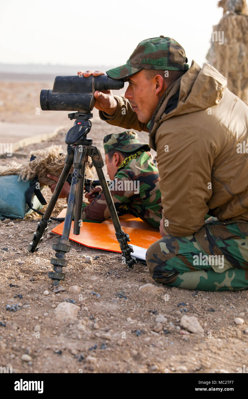An Iraqi security forces member spots for a fellow classmate firing a ...