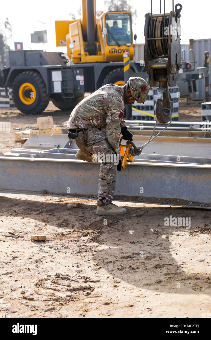 A United Kingdom training team member secures a support beam for ...