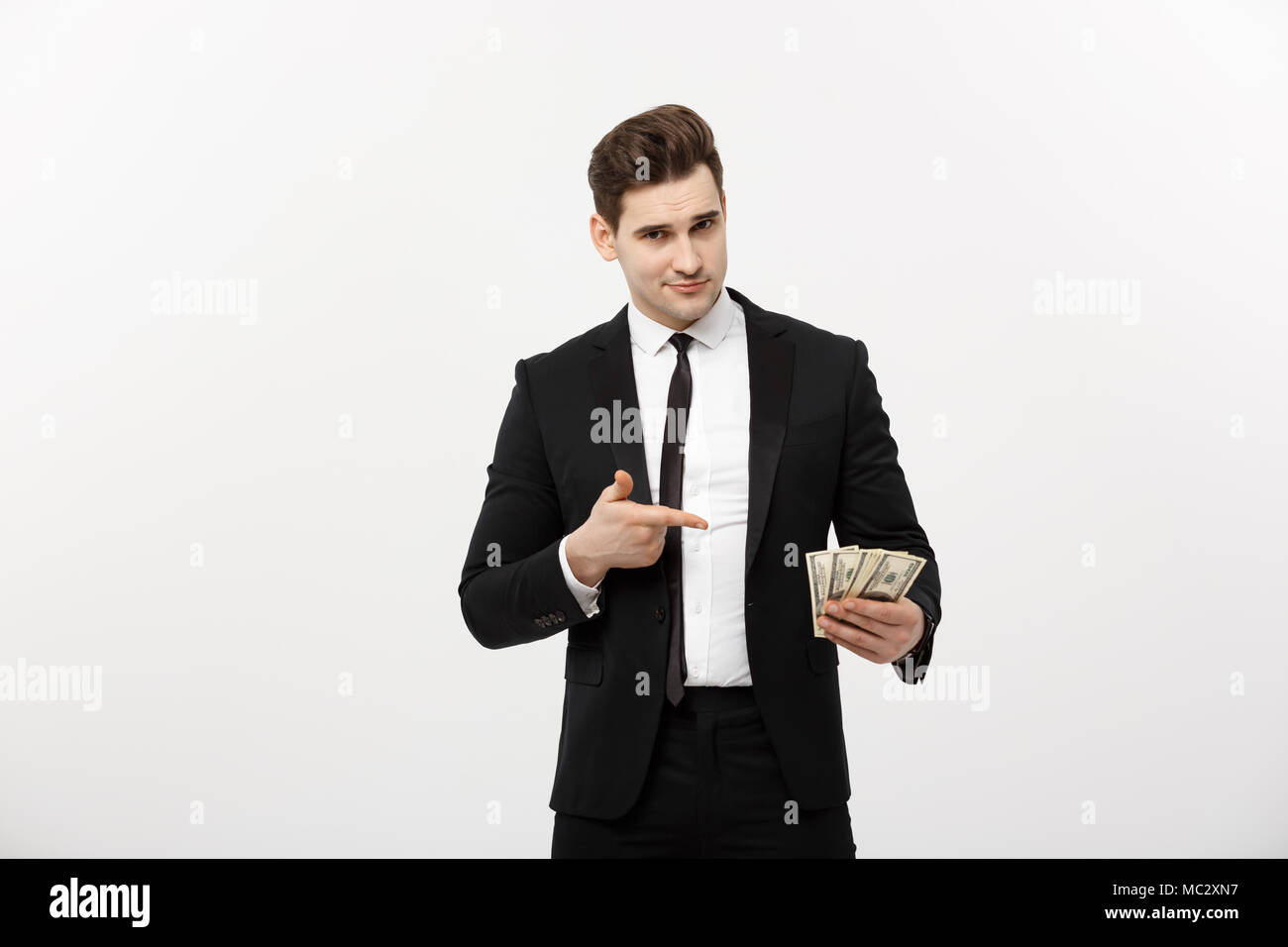Business Concept: Handsome Businessman in suit pointing finger to money ...
