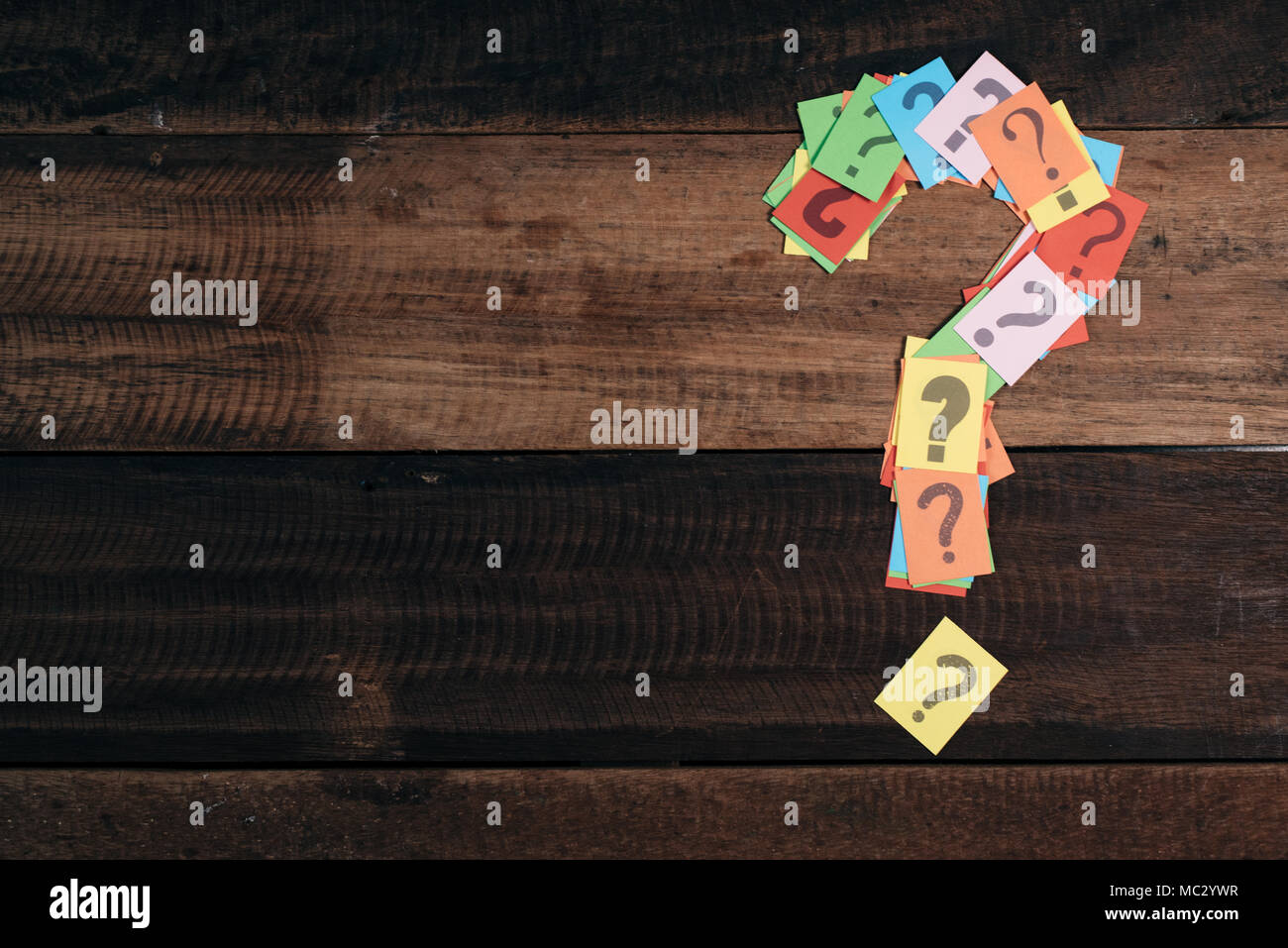 multicolored paper with QUESTION MARK on a wooden table background ...