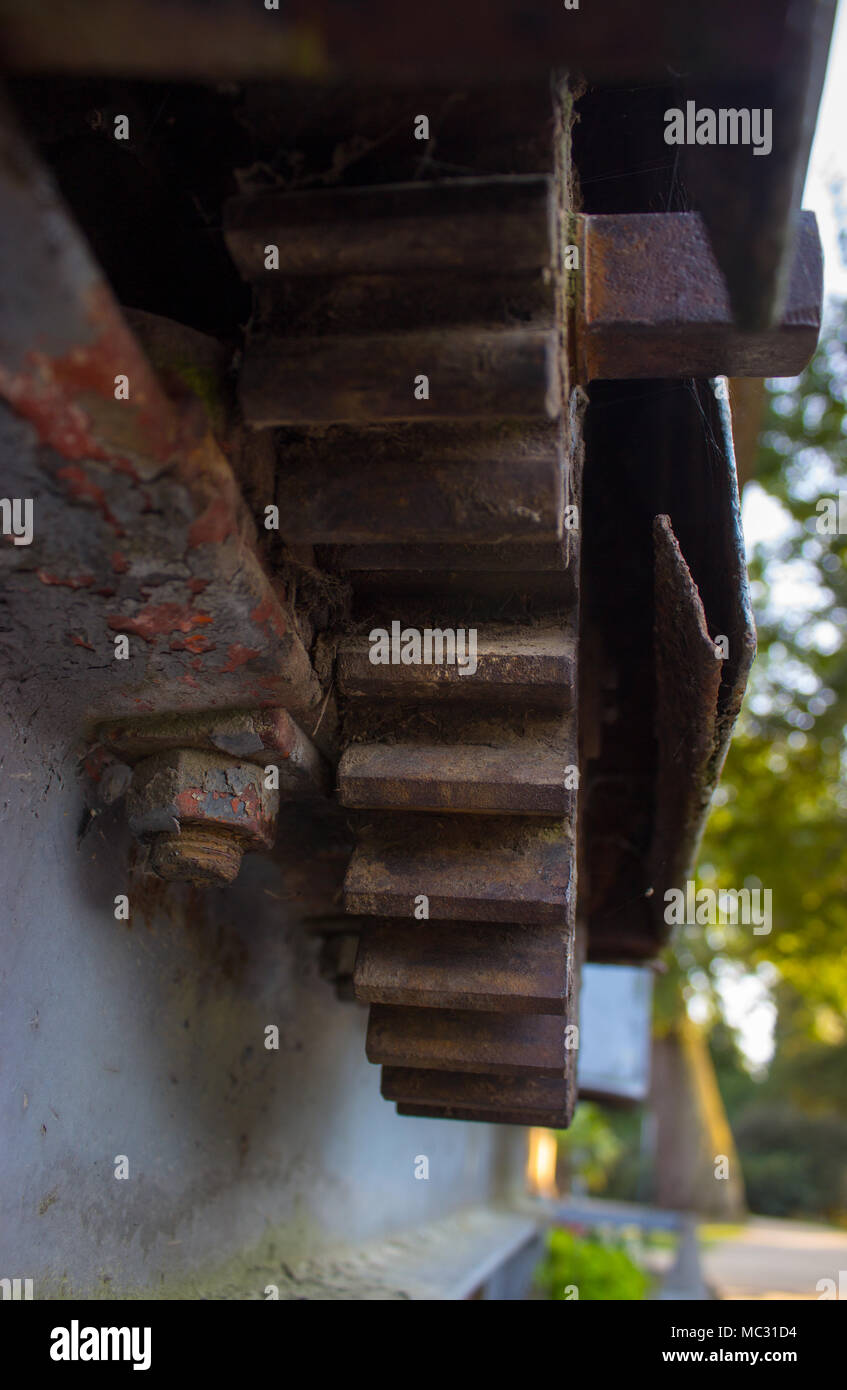 Old rusty cogwheel. In the background are trees Stock Photo - Alamy
