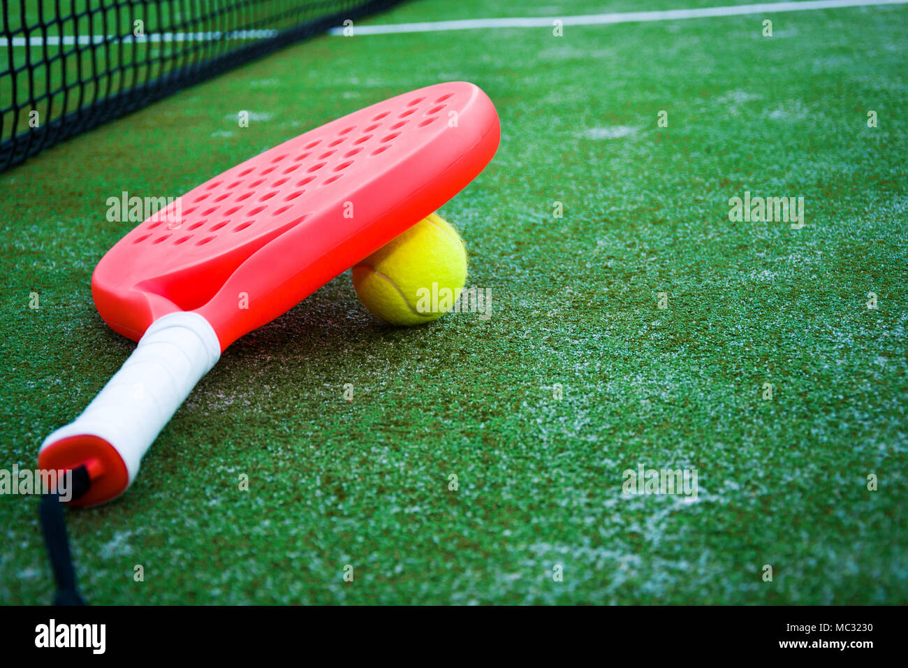 Paddle tennis racket, ball and net on the grass. Copyspace Stock Photo ...