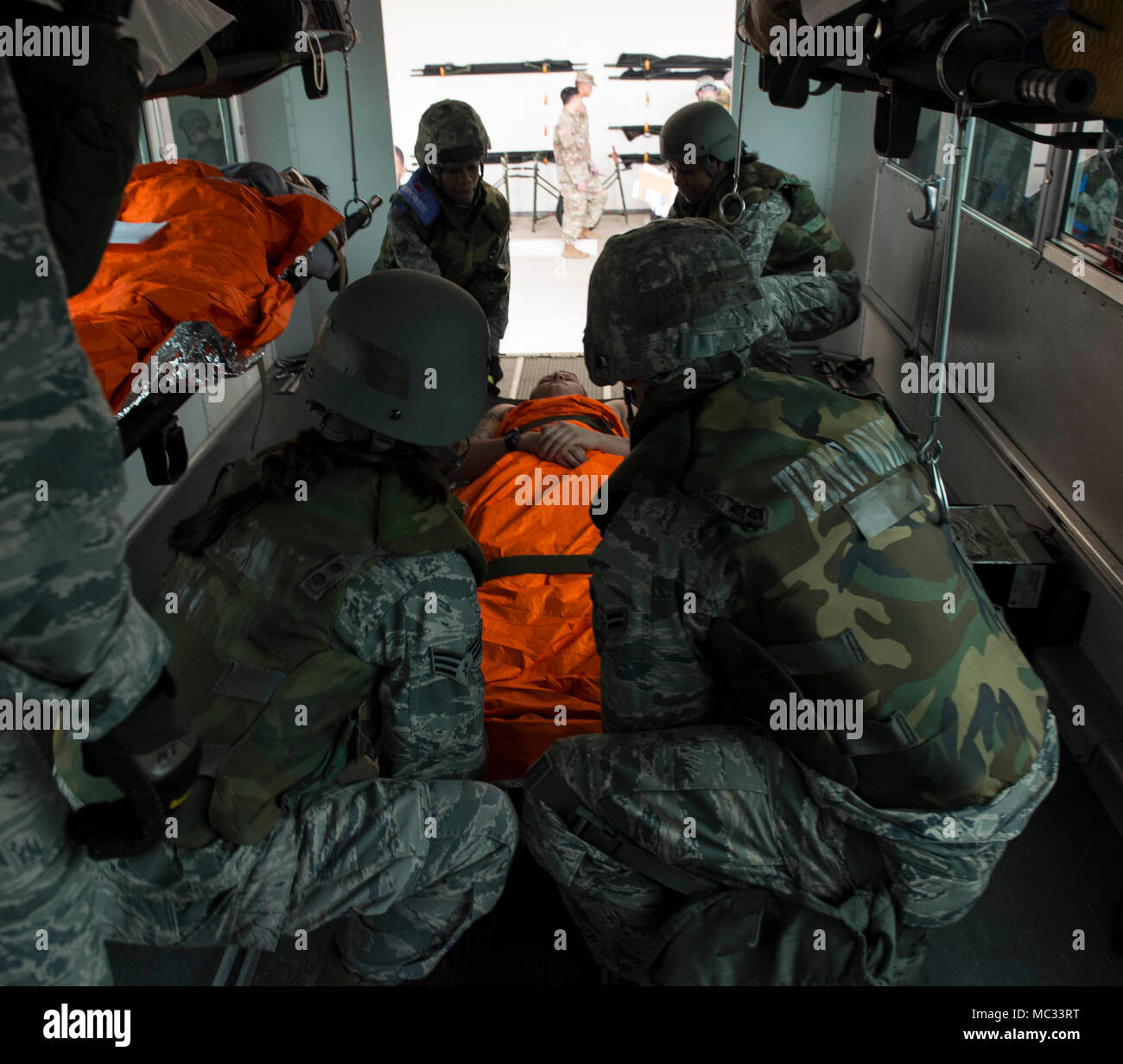A simulated patient is loaded for transportation during a joint field ...