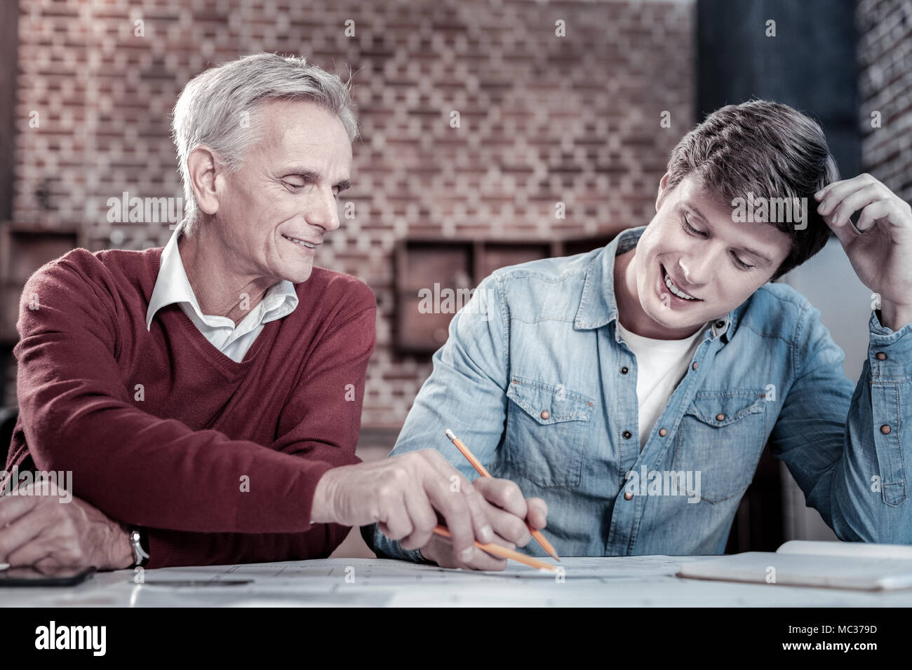 Skillful male engineers finishing blueprint Stock Photo - Alamy