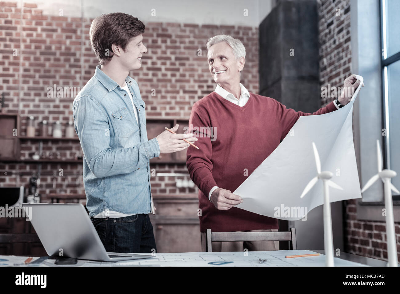 Inspired male engineers perfecting blueprint Stock Photo - Alamy