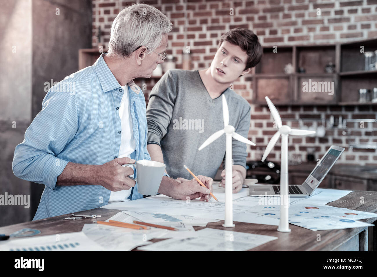 Pensive male engineers sharing experience Stock Photo - Alamy