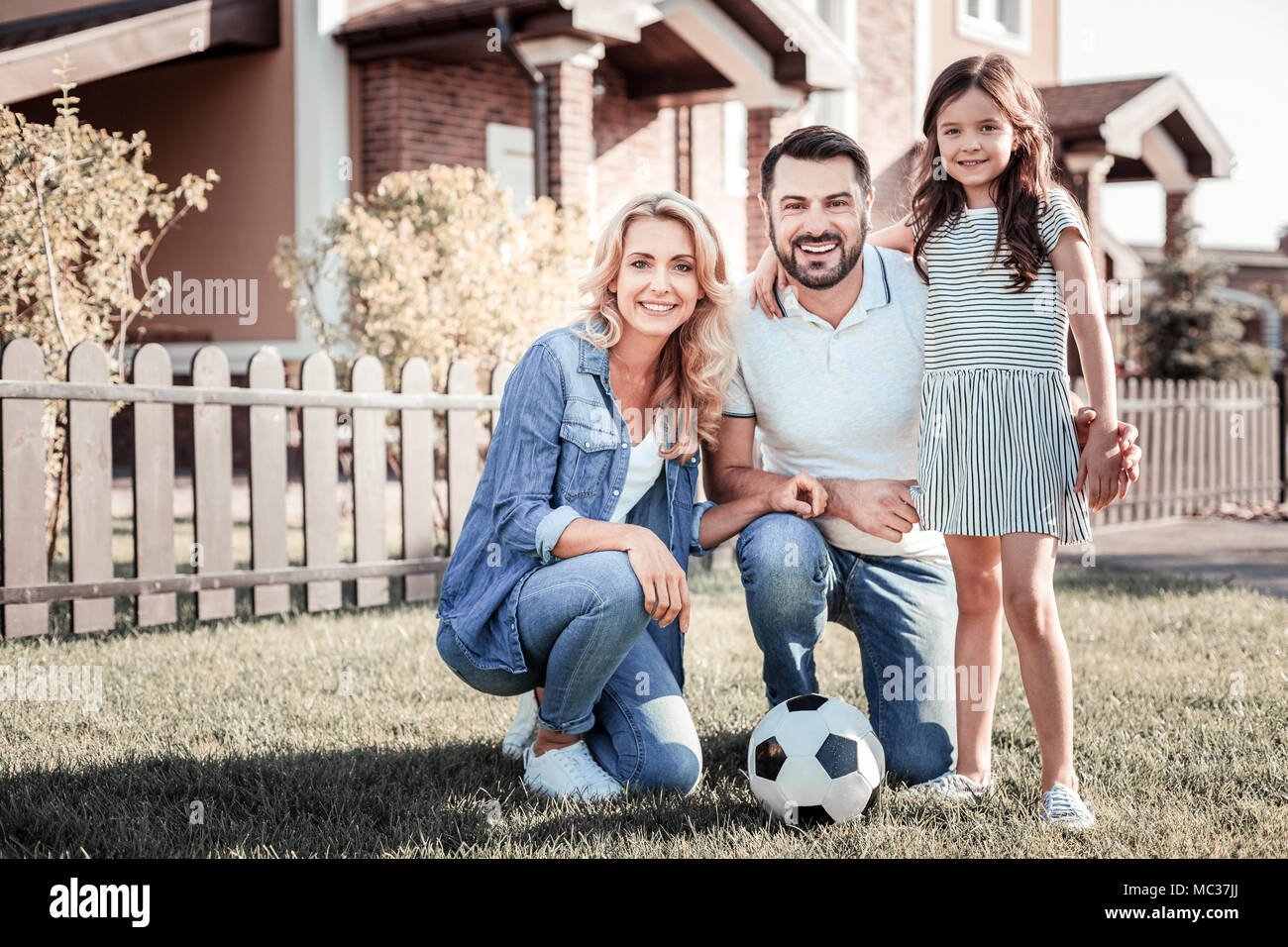 Pretty friendly family smiling and standing together Stock Photo - Alamy