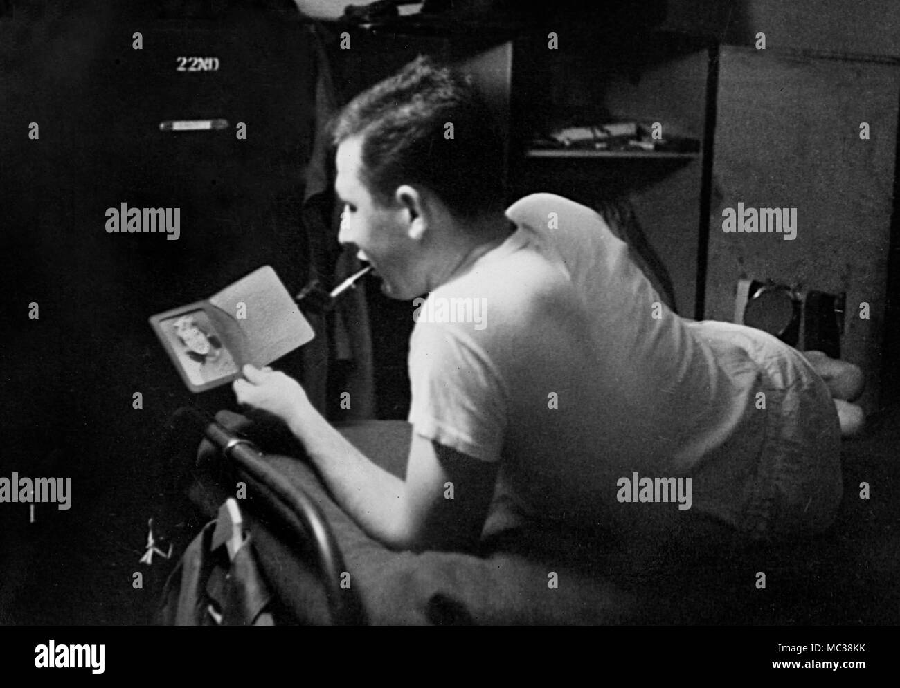 Snapshot of a World War II soldier laying in his bunk and gazing at a ...