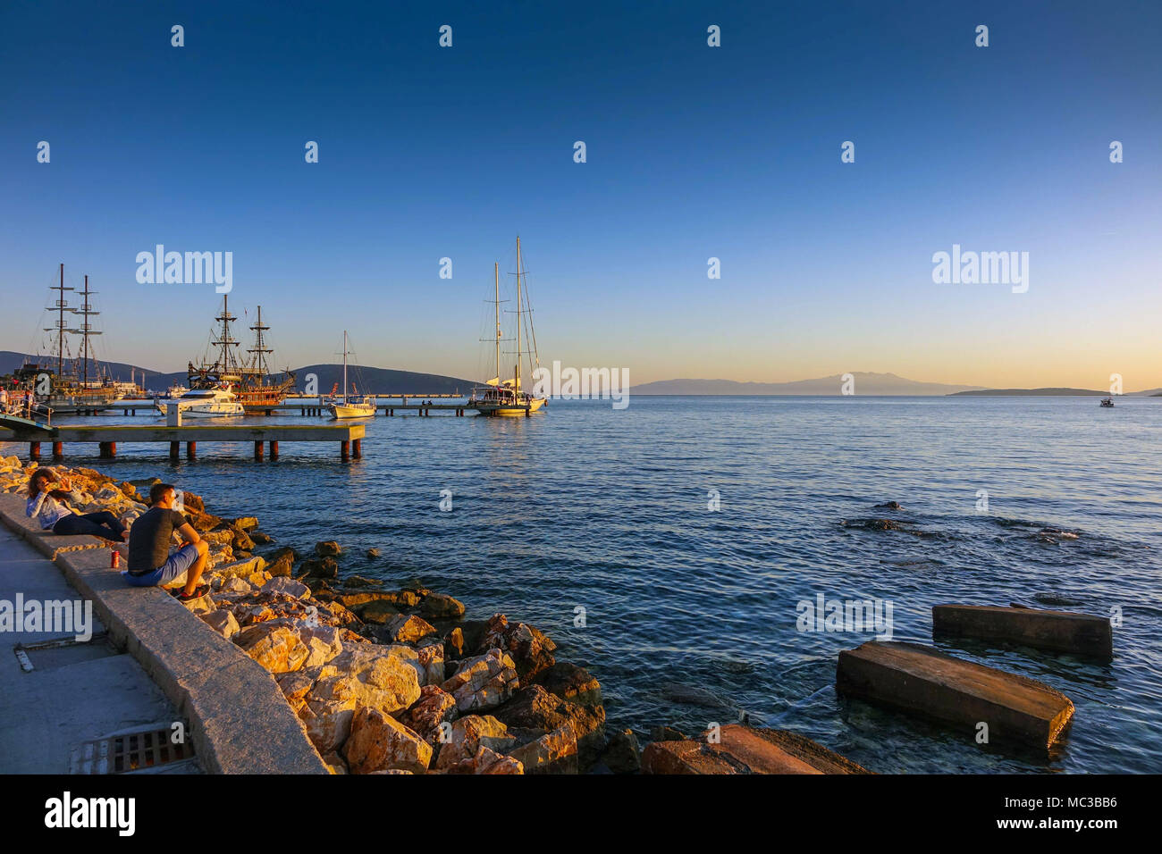 Two people watching sunset, Ships moored, evening, at seafront, Bodrum ...