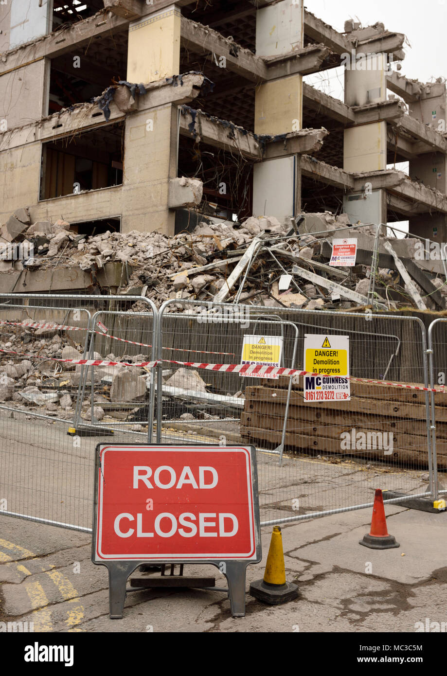 Road closed sign in front of fenced off partly demolished reinforced ...