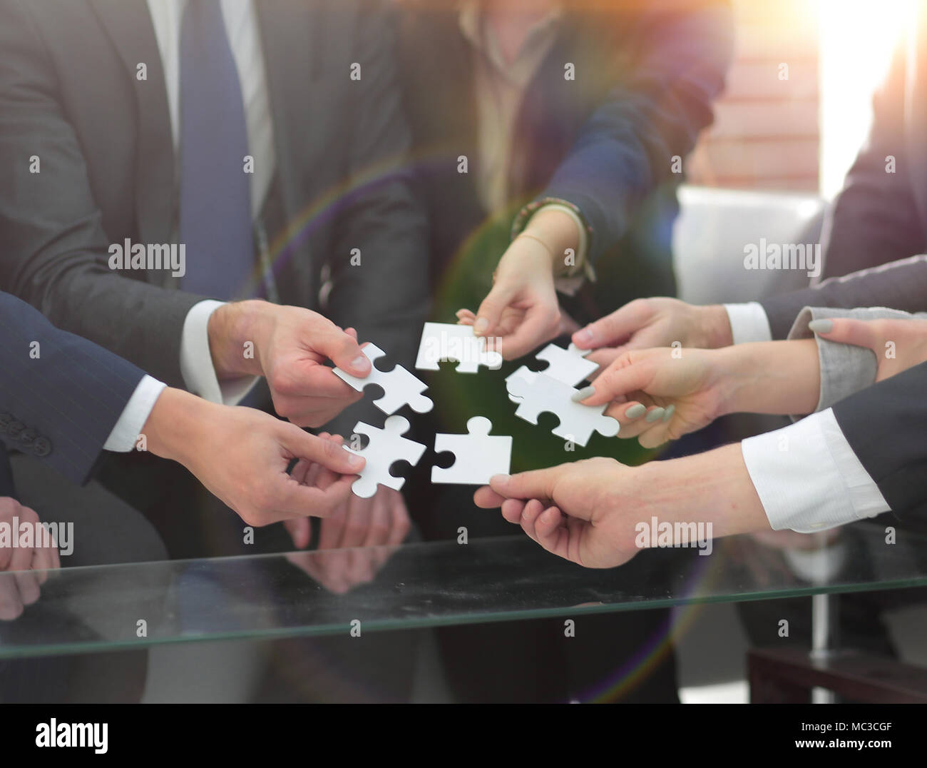 Business team solving puzzle together Stock Photo - Alamy