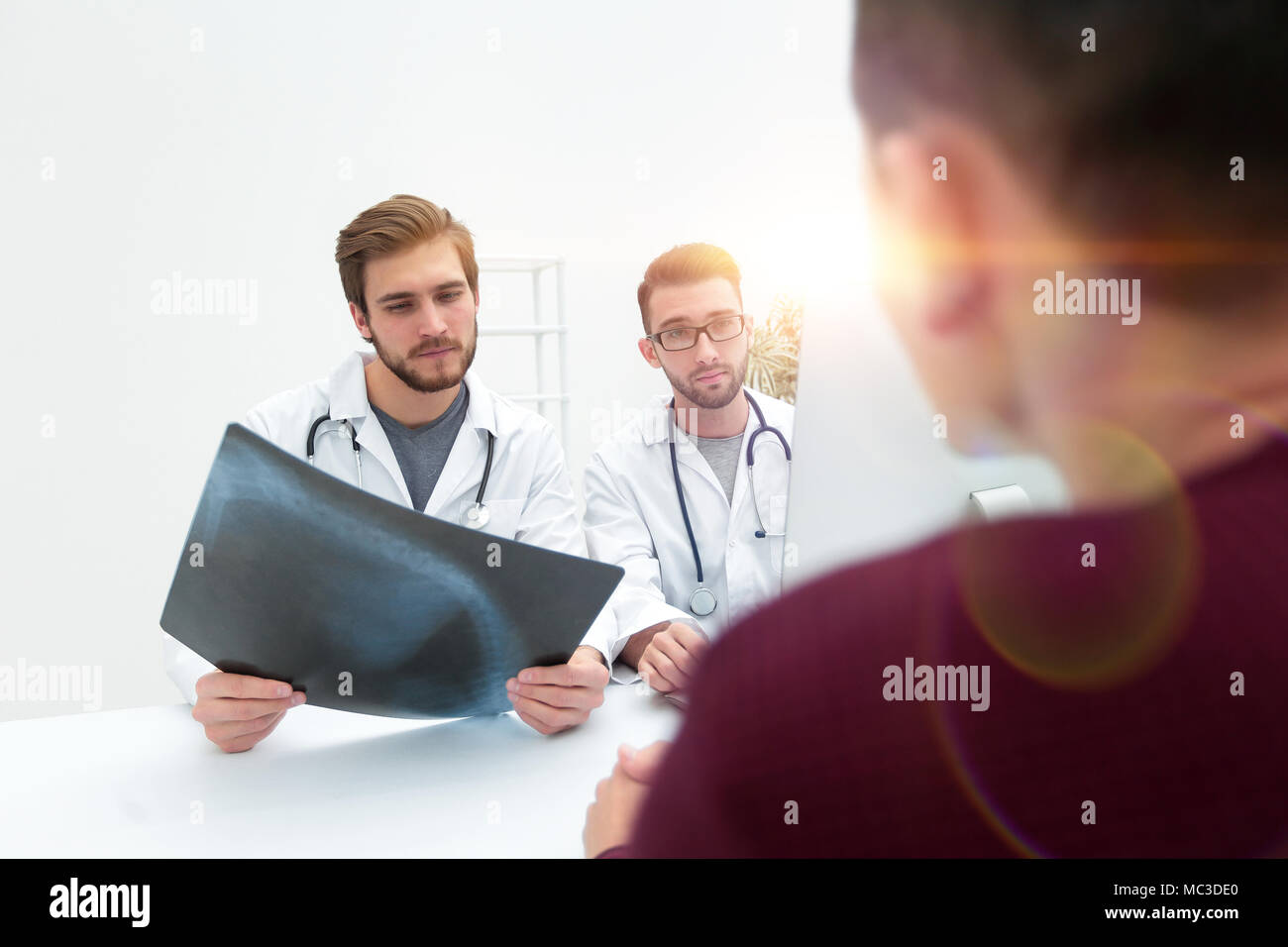two doctors examining an x-ray of a patient in a medical office Stock ...