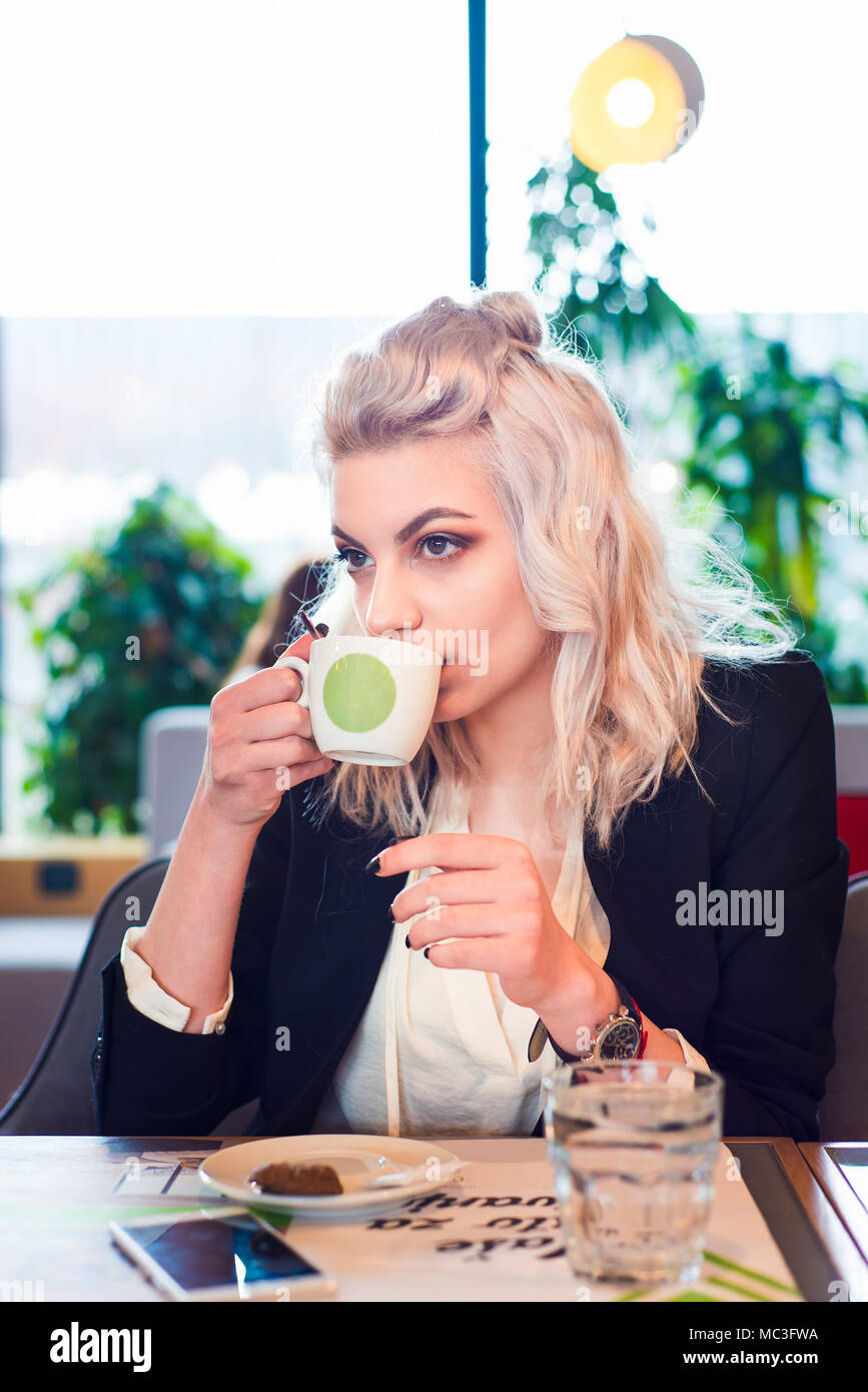 Beautiful young woman drinking coffee Stock Photo - Alamy