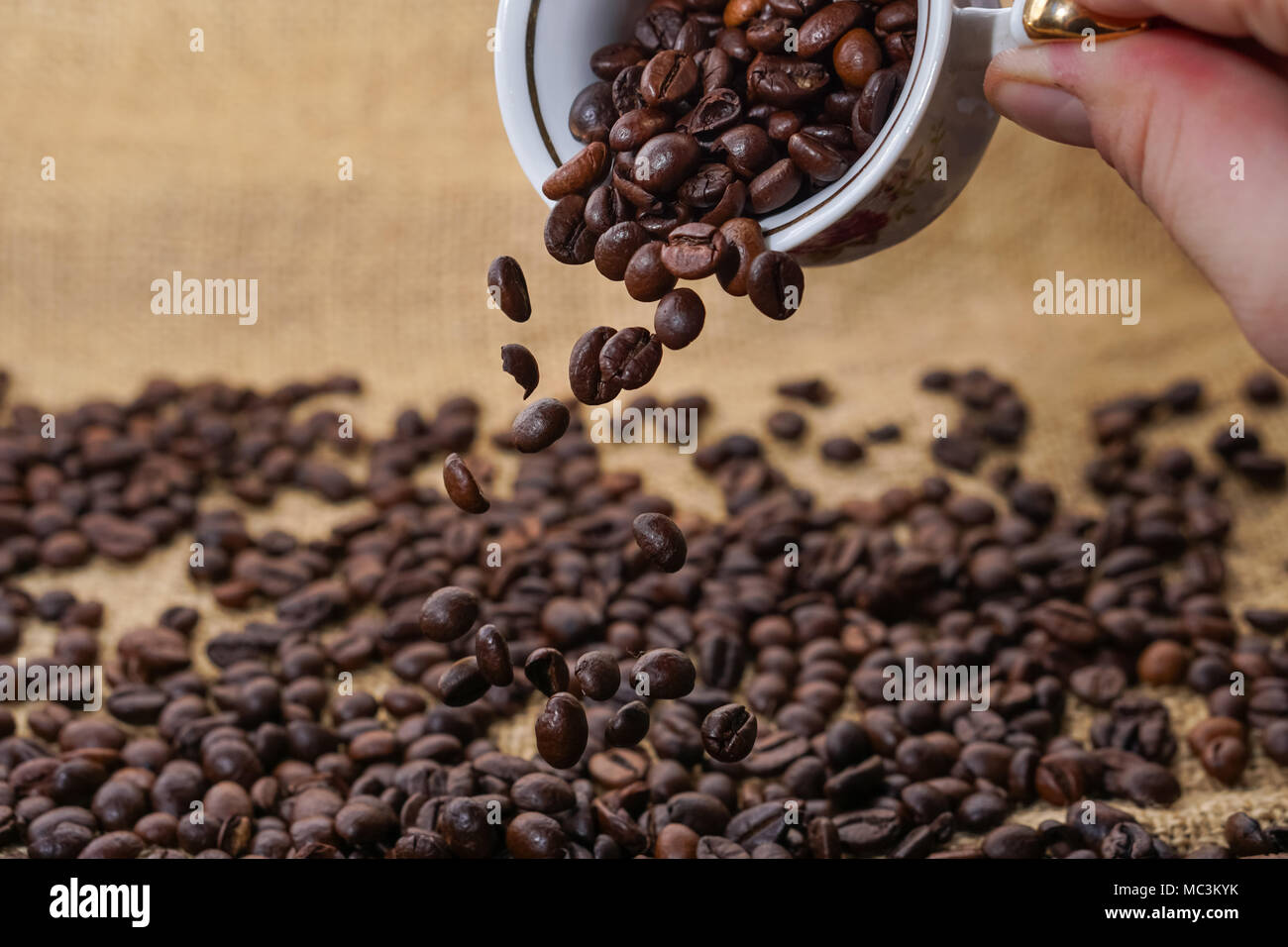 Spilling out coffee beans from cup Stock Photo - Alamy
