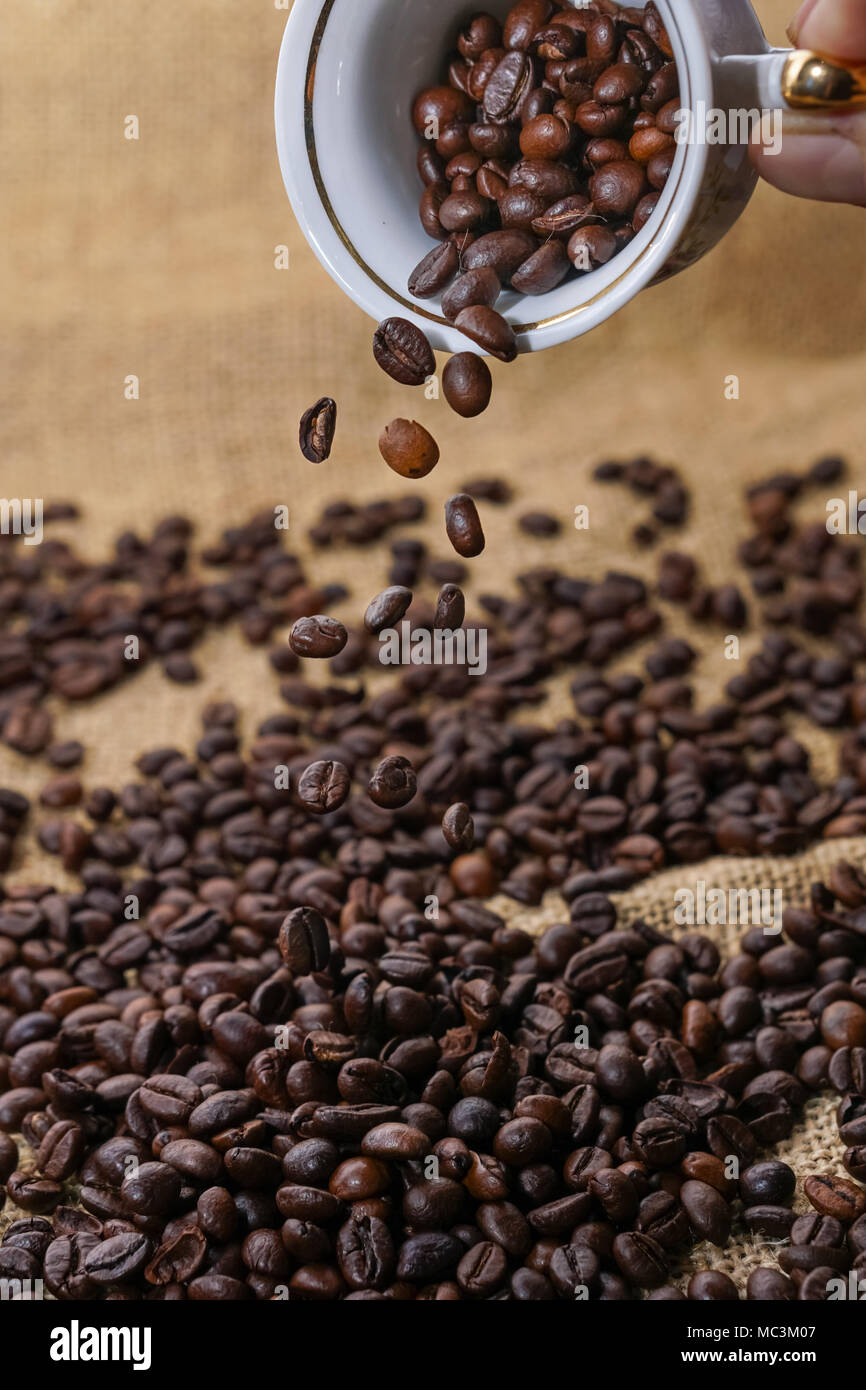 Spilling out coffee beans from cup Stock Photo - Alamy