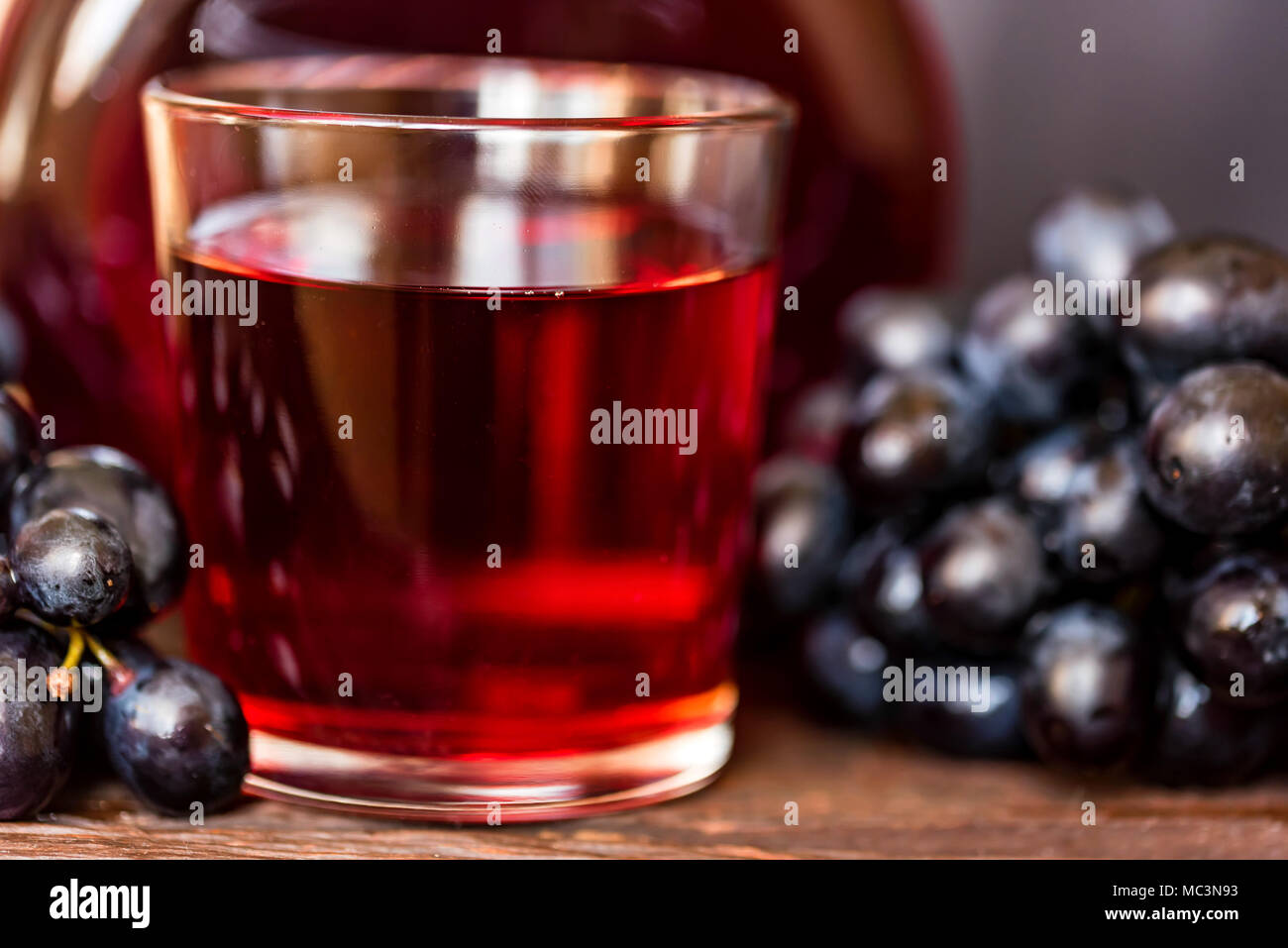 Red grape juice in glass and grapes close Stock Photo - Alamy