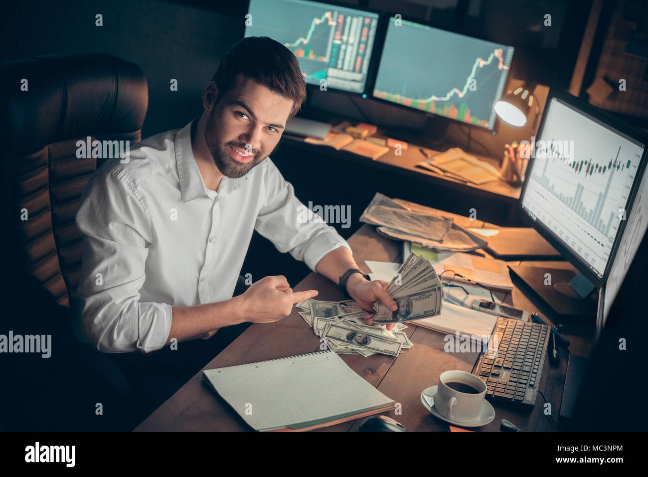Man pointing finger at his salary and toothy smiling. Indoor, studio ...