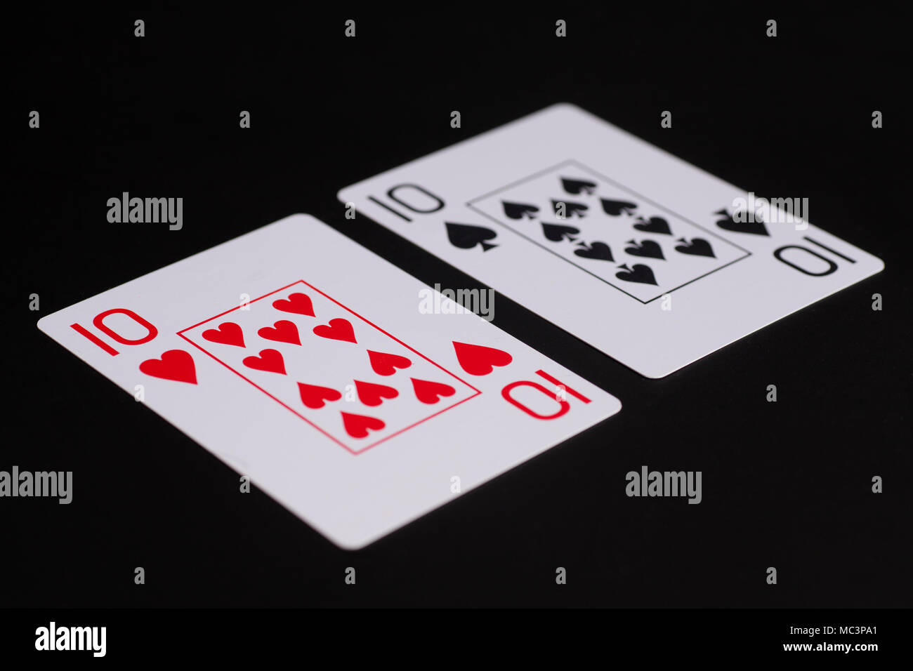 Ten of spades and ten of hearts playing card on black background Stock ...