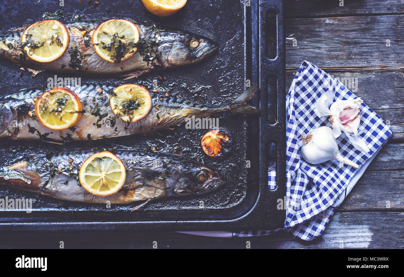 Baked fresh mackerel fish, with lemon and seasoning, on baking tray ...