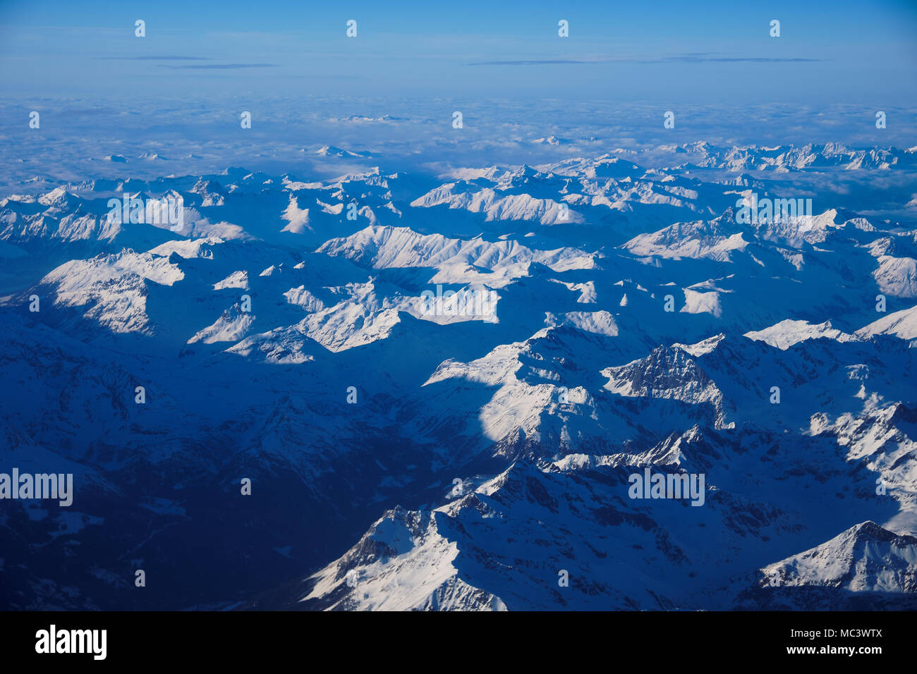 Bird's eye view of mountainscape covered in snow from an airplane Stock ...
