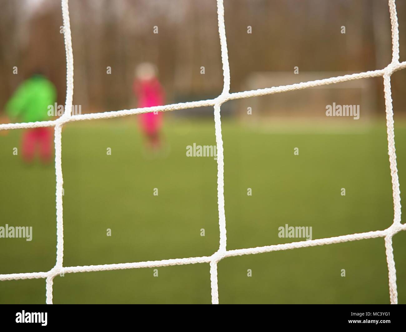 Football player stands against goal with net and stadium. Football gate ...
