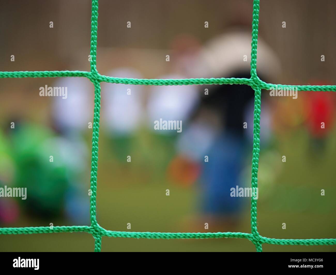 Football player stands against goal with net and stadium. Football gate ...