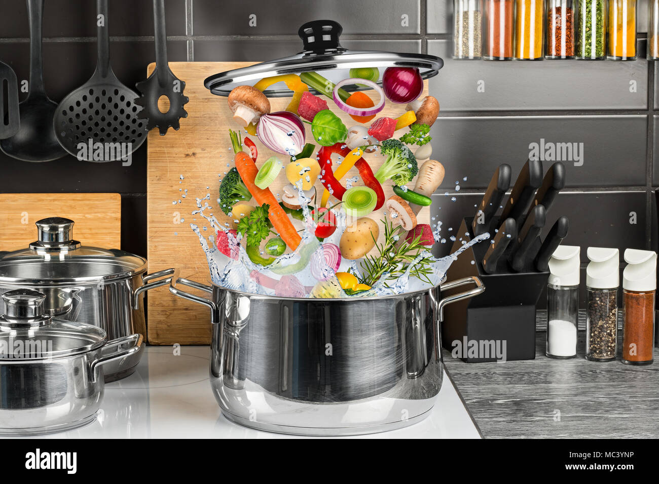 vegetable meat ingredients falling into stainless steel cooking pot ...