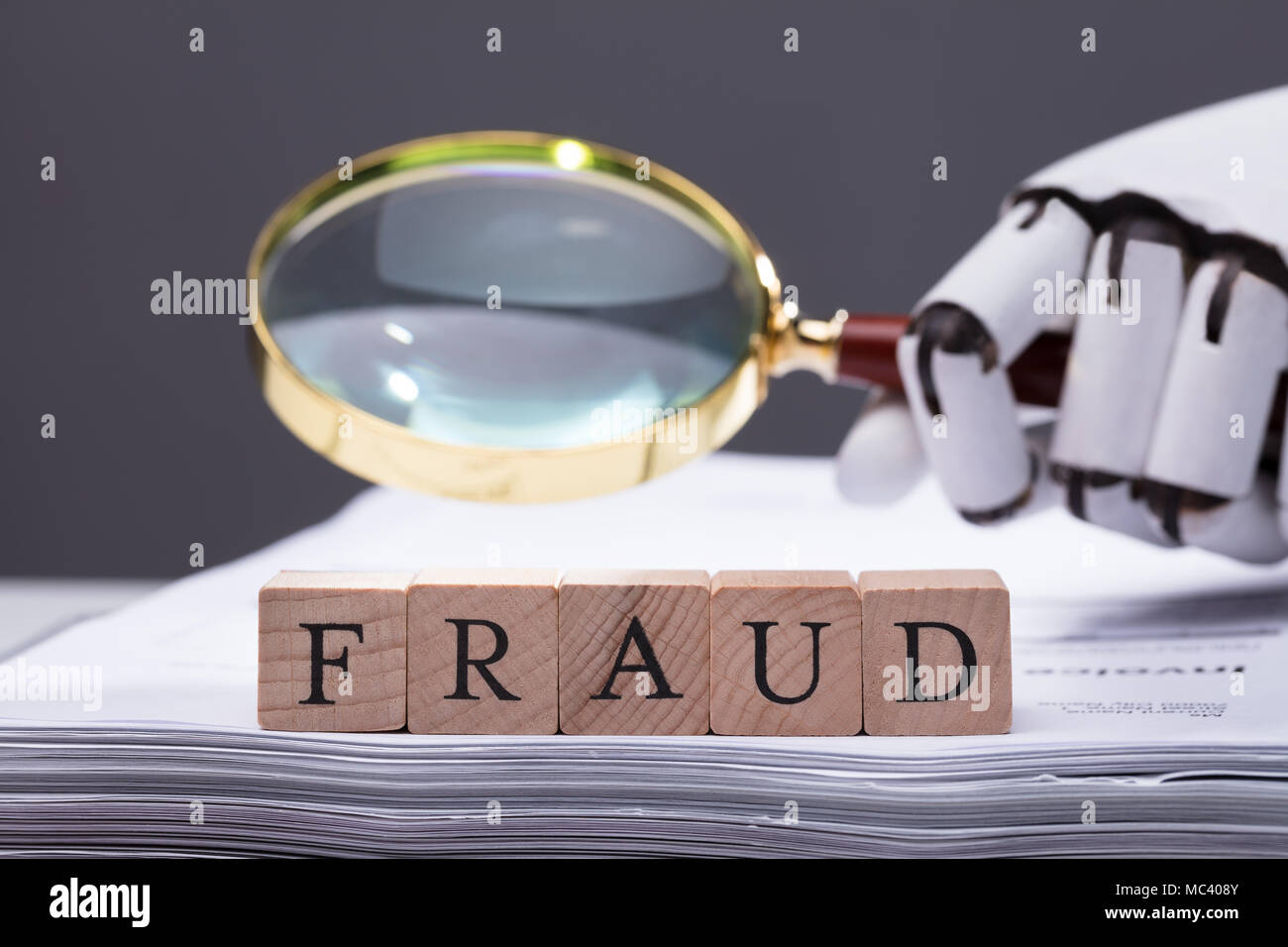 Robot Hand Holding Magnifying Glass Over Wooden Block With Fraud Text ...