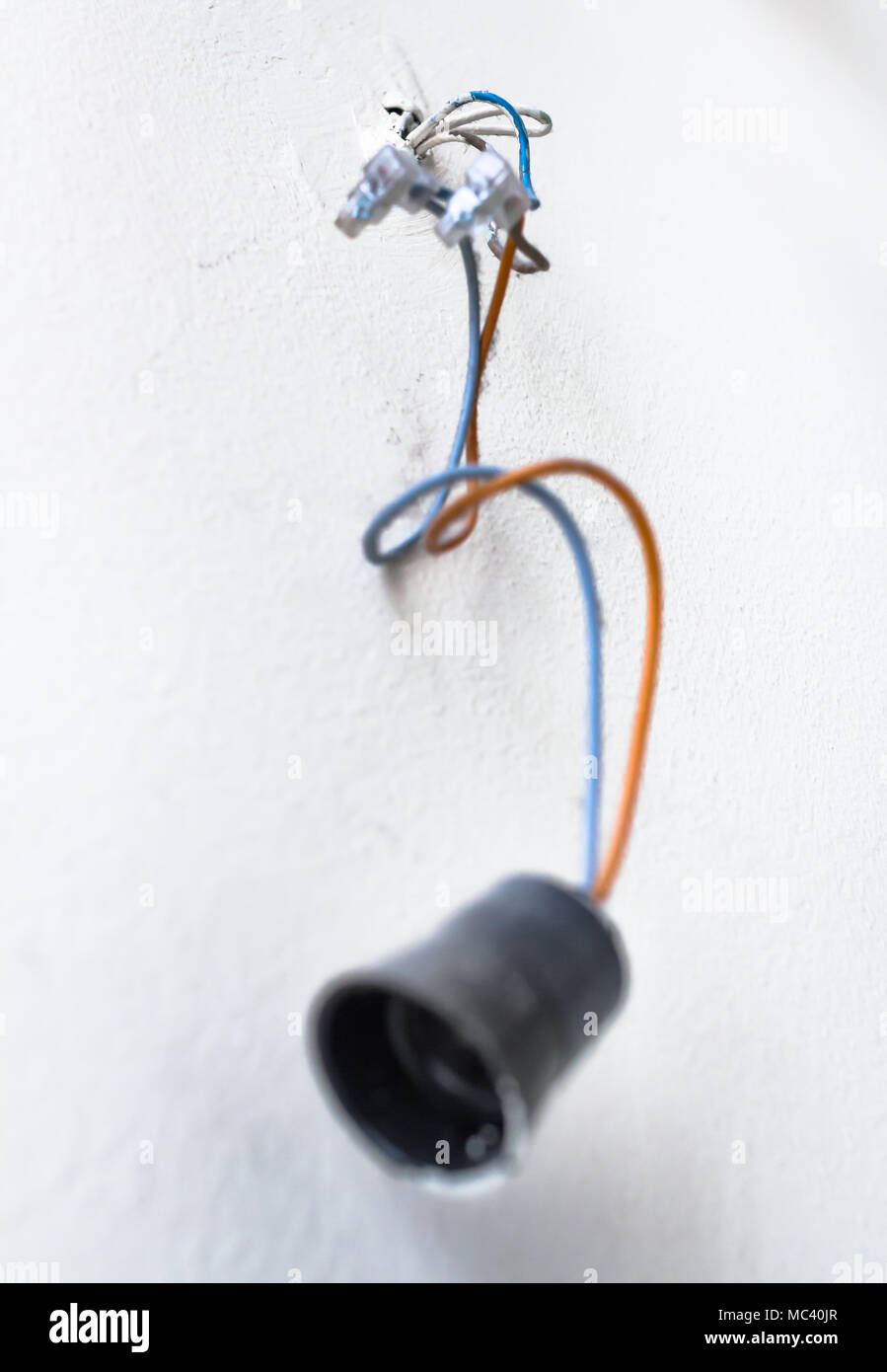 Dangerous bad wiring leading to the bulb on a white wall Stock Photo ...