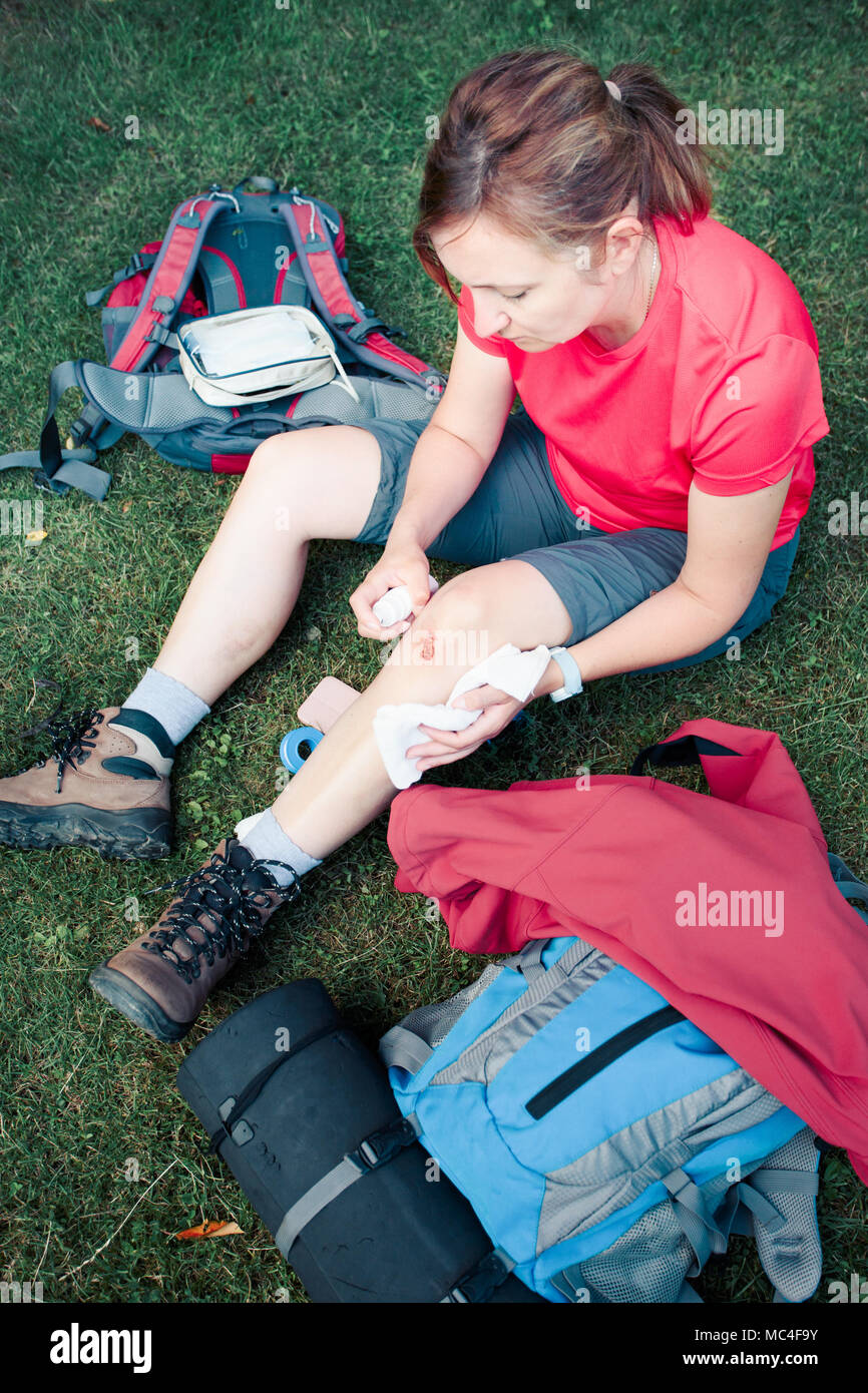 Woman injured in the accident on mountain hike. Dressing the wound on ...